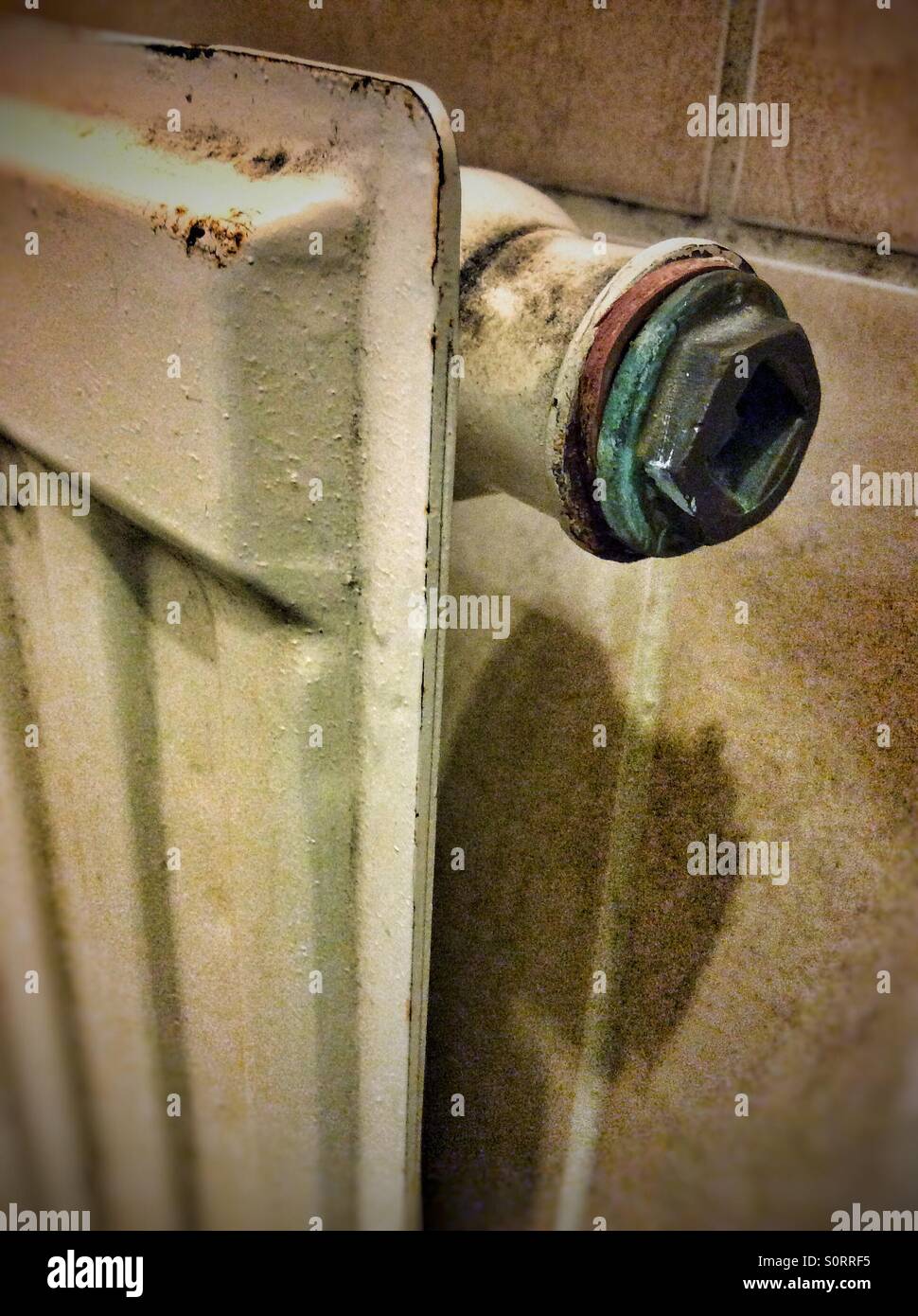 The bleed valve at the end of a bathroom radiator to vent air from the ...