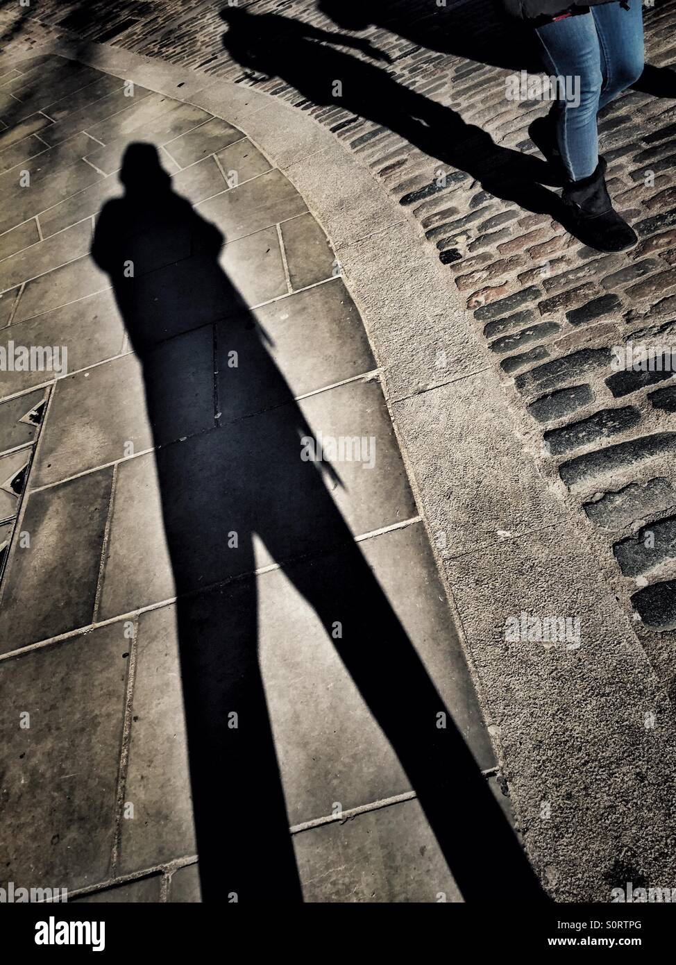 Long winter human shadows on pavement and cobbles Stock Photo - Alamy
