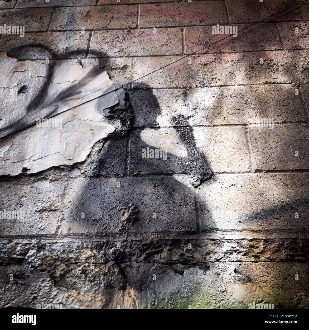 A dark silhouette of a man smoking decorates a wall polluted by smog in ...