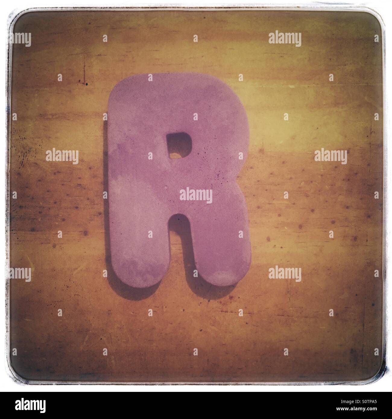 Textured foam letter R on a grungy wood background Stock Photo - Alamy