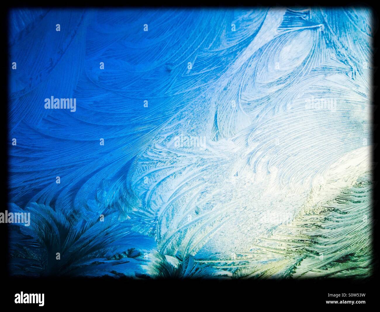 Frozen covered glass window displays patterns of art Stock Photo - Alamy