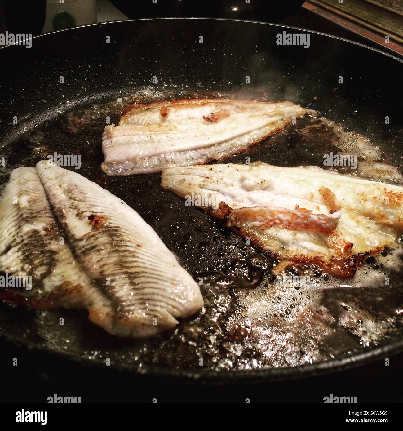 Cooking, baking fish in a stainless steel pan Stock Photo - Alamy