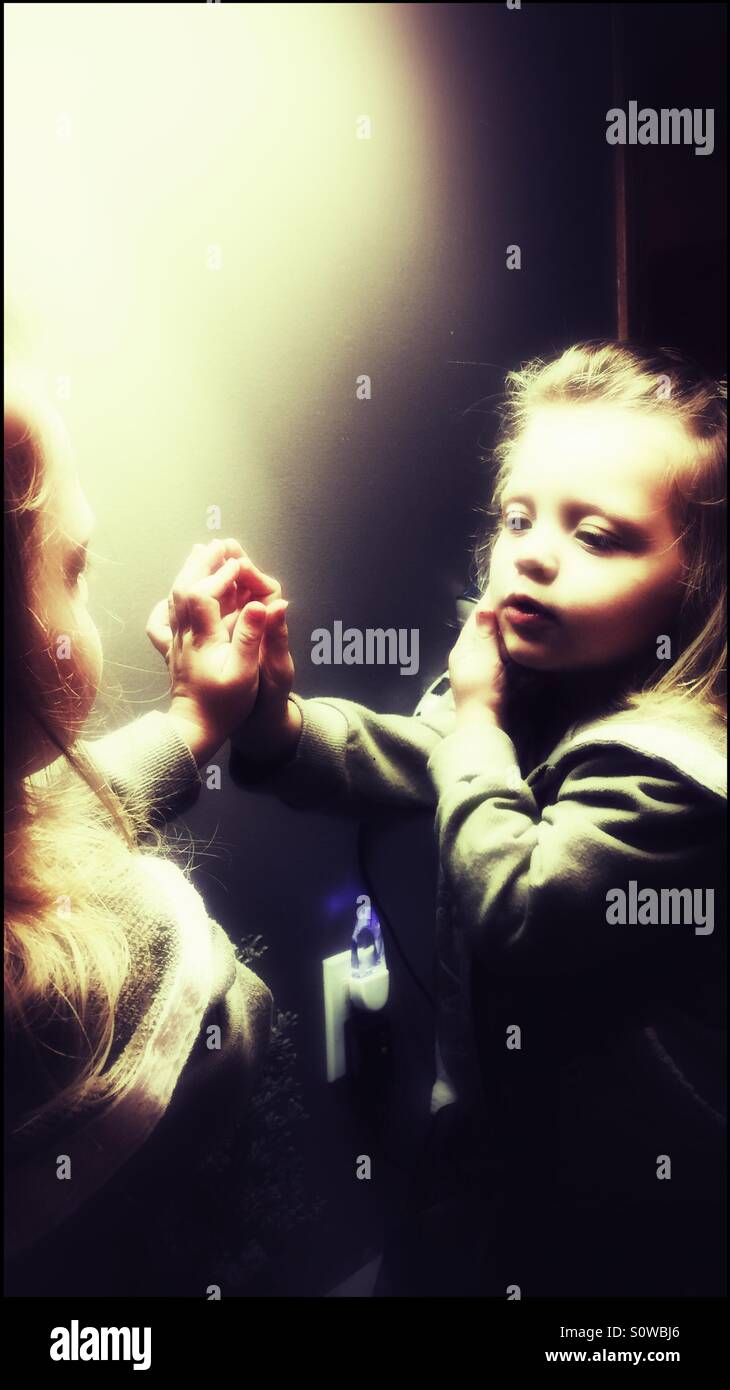 Little girl primping in the mirror Stock Photo - Alamy