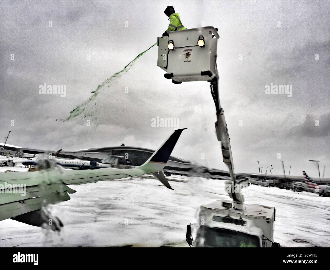 De-icing a plane during winter storm Stock Photo - Alamy