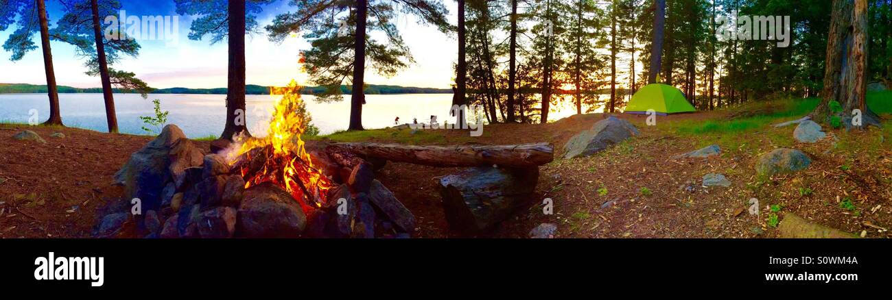 Lakeshore Campfire By Log Bench At Lake Sunset Stock Photo - Alamy