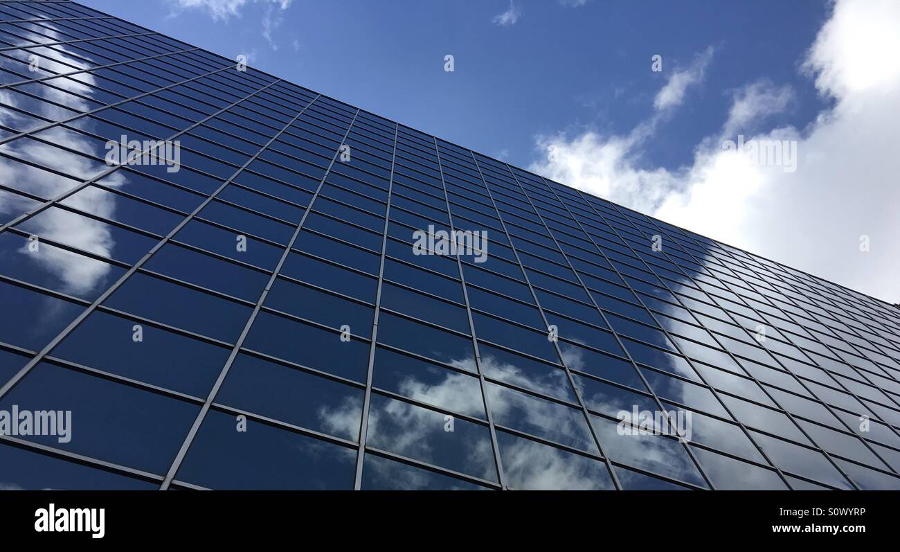 Clouds reflected in windows of large building Stock Photo - Alamy
