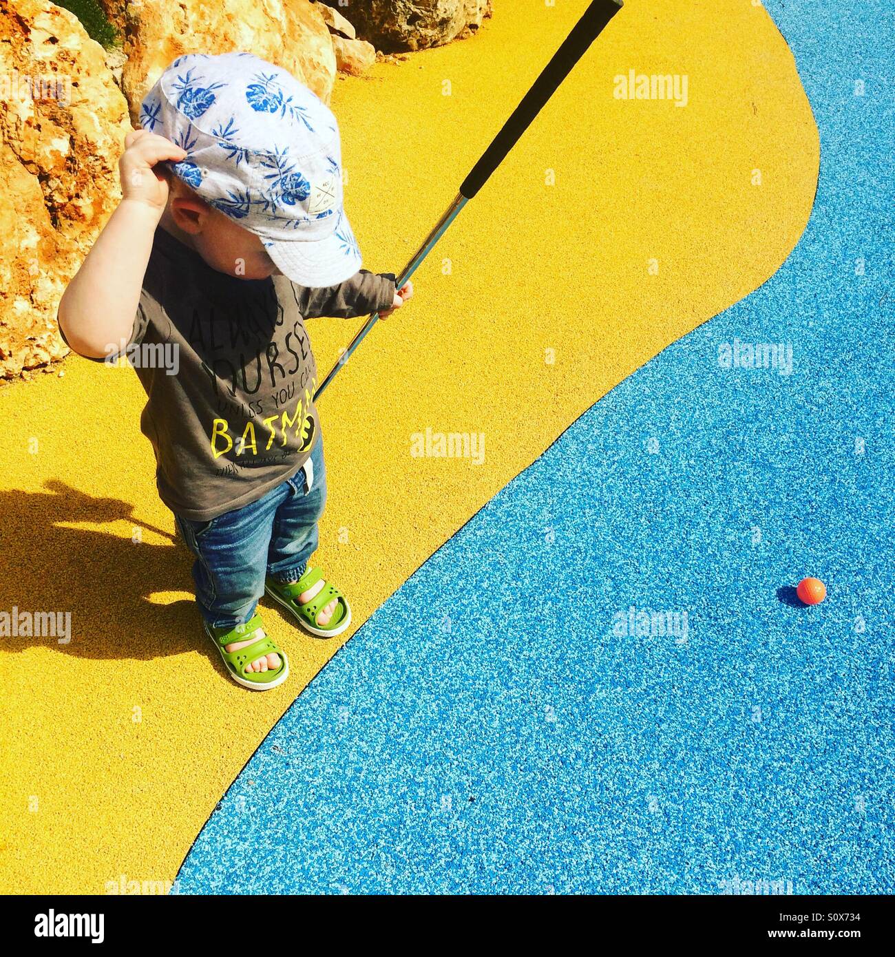 Toddler boy playing mini golf Stock Photo - Alamy