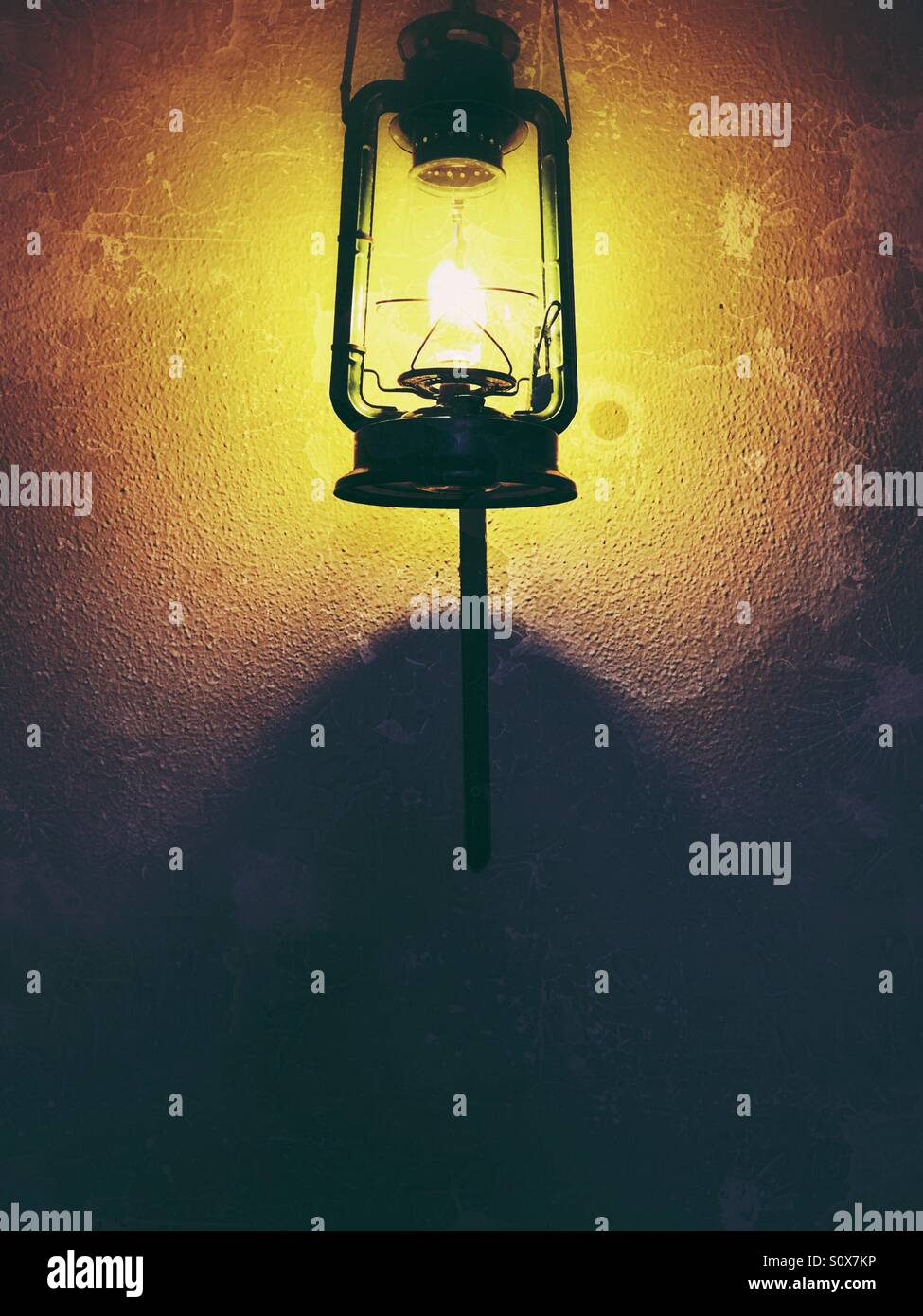 Lit lamp against wall Stock Photo - Alamy
