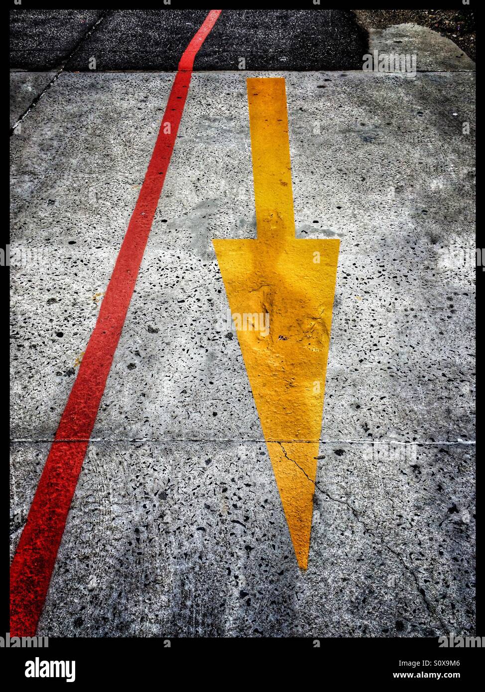 Yellow arrow and red line on road Stock Photo - Alamy