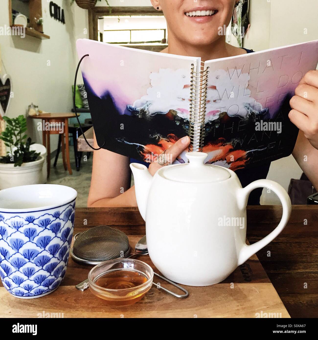 Woman at the table reading from notebook Stock Photo - Alamy