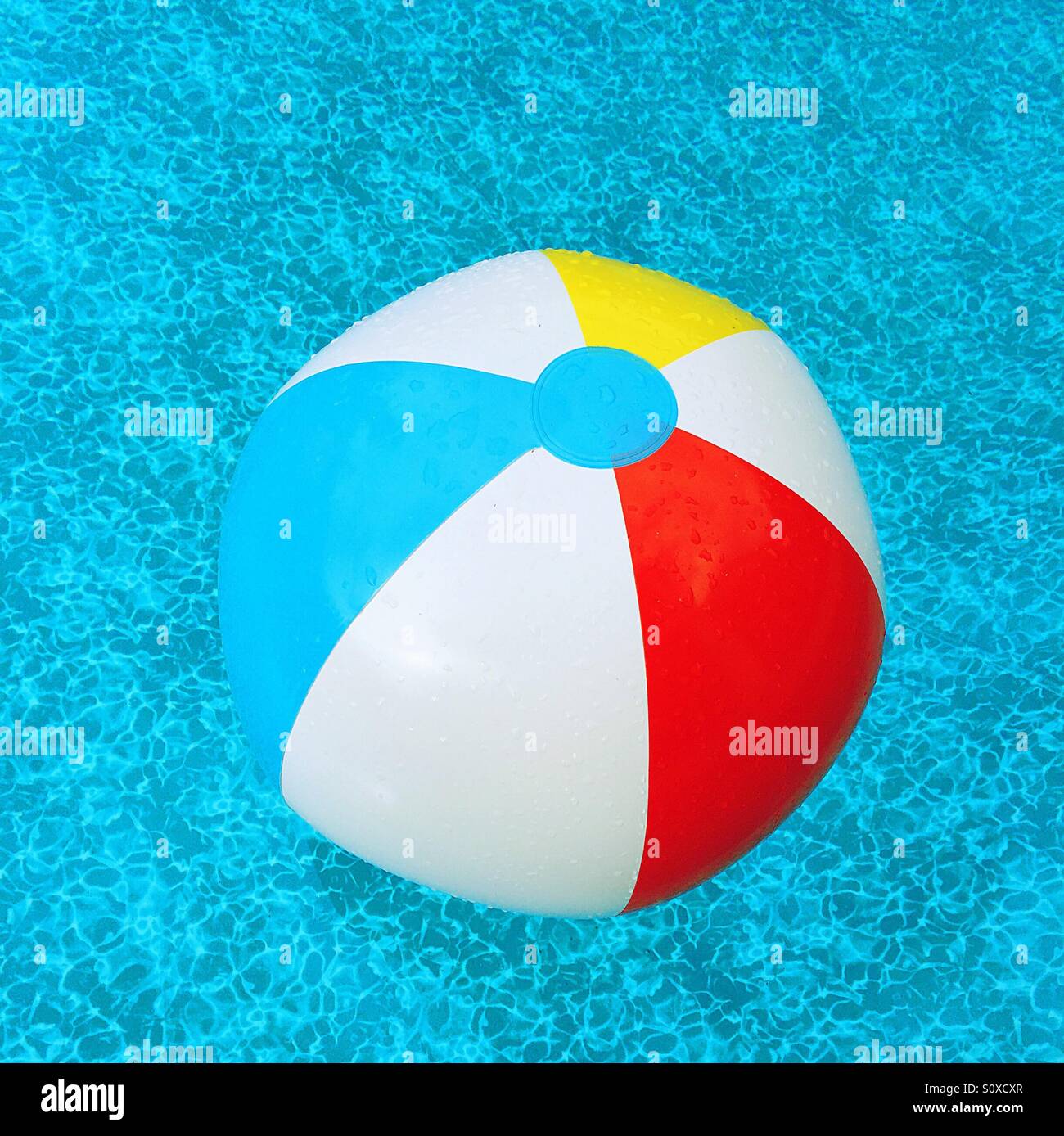 Beach ball floating in swimming pool Stock Photo - Alamy