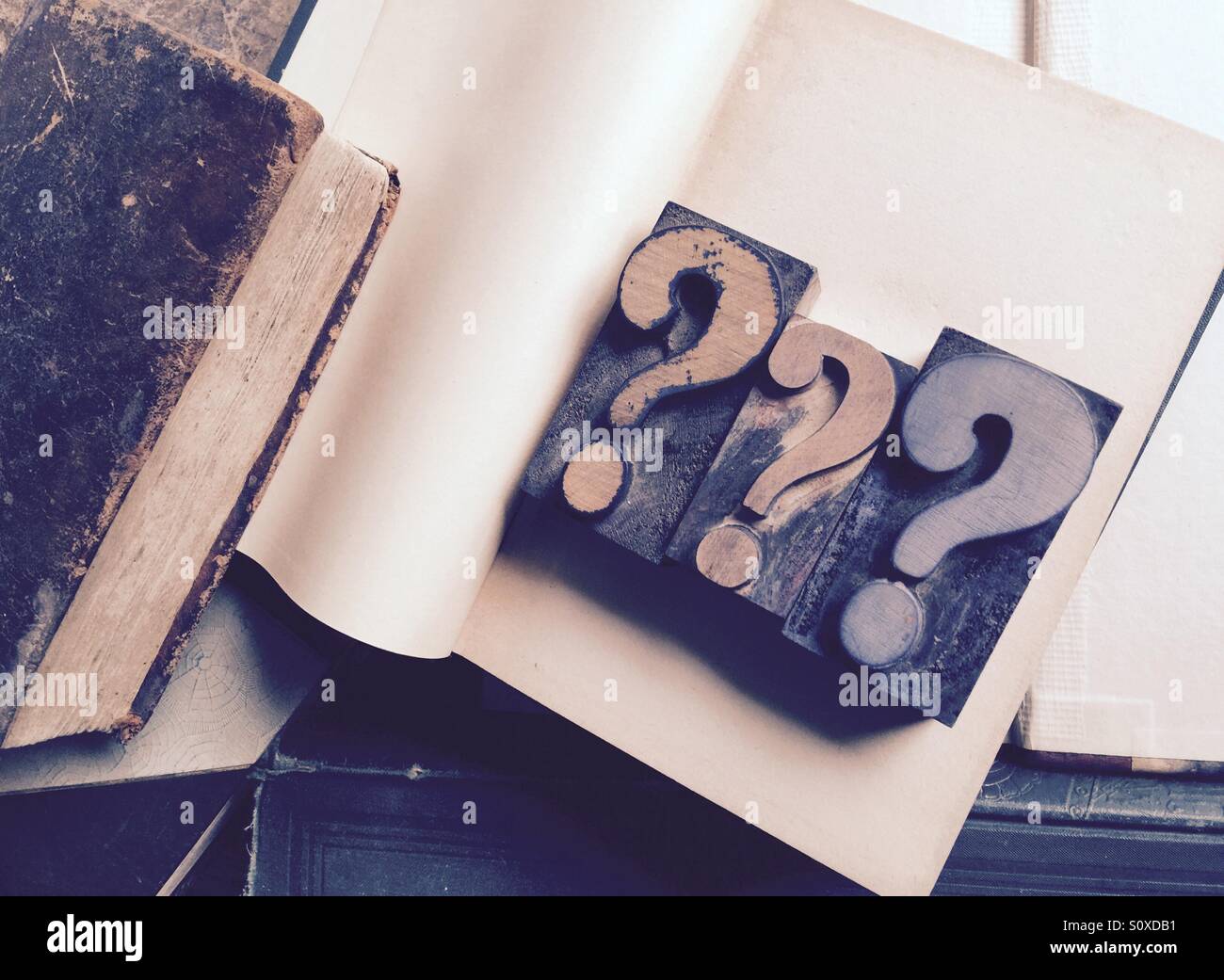 Open book with wood type question marks Stock Photo - Alamy
