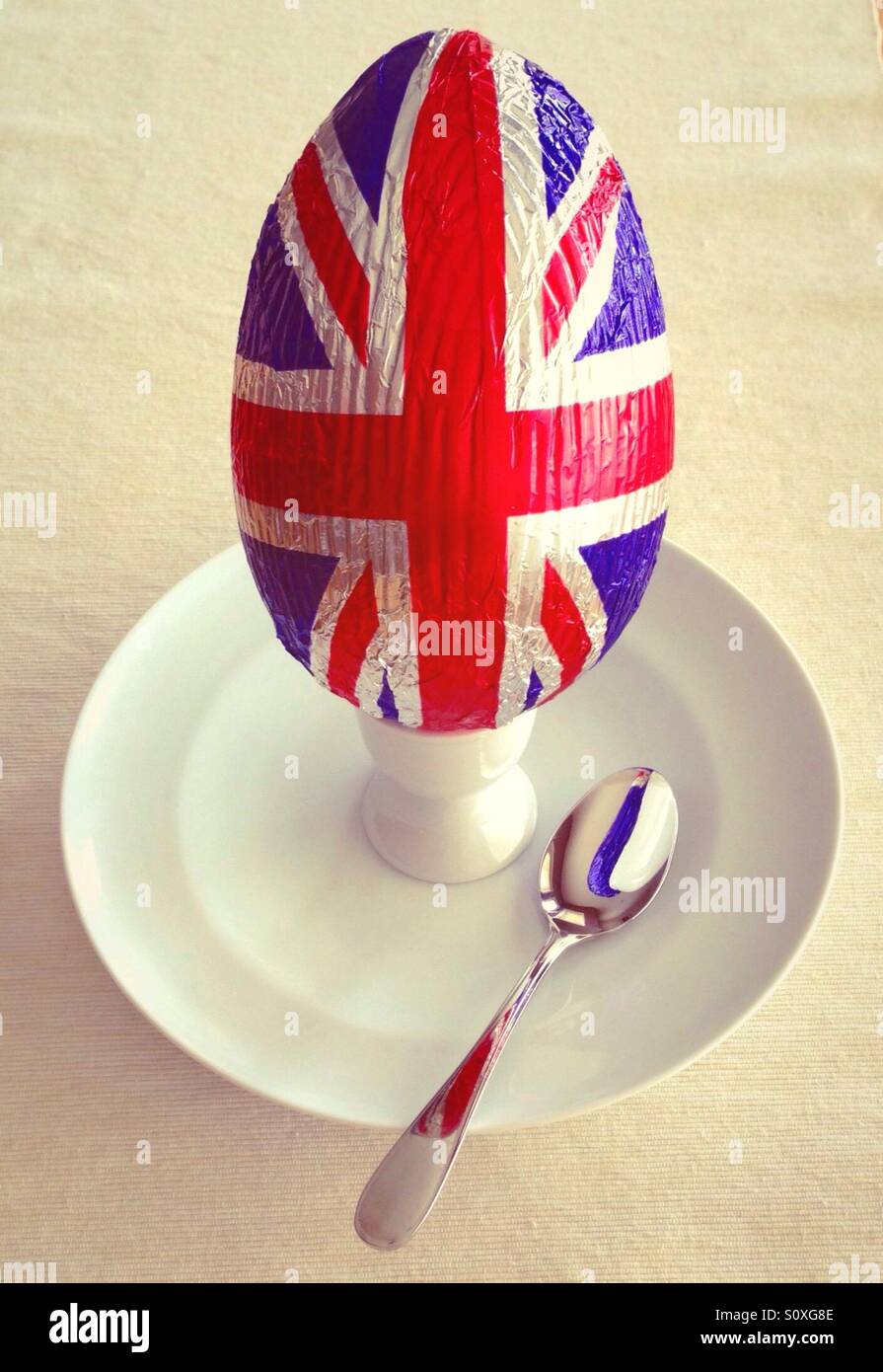 Chocolate Easter egg in Union Jack foil, on an egg cup and plate with a ...