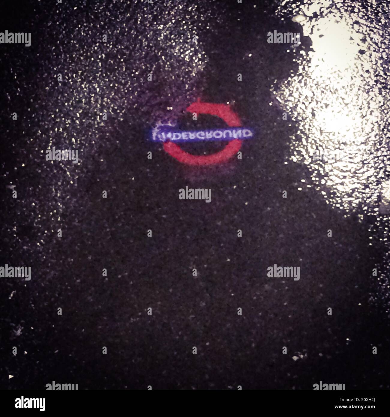London Underground logo reflected in puddle Stock Photo - Alamy