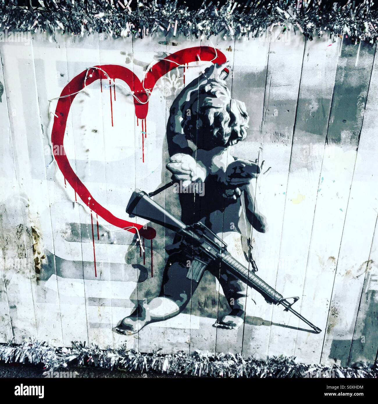 Street art Cupid with a gun painting a love heart Stock Photo - Alamy
