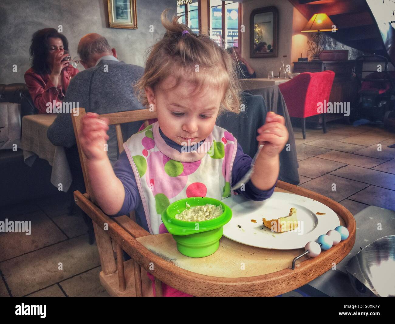 Baby eating by herself Stock Photo - Alamy