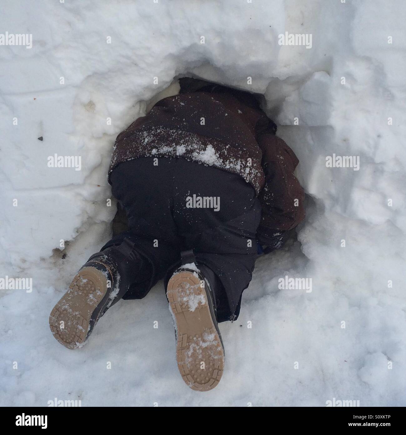 A boy digging a snow cave after a spring snowstorm Stock Photo - Alamy