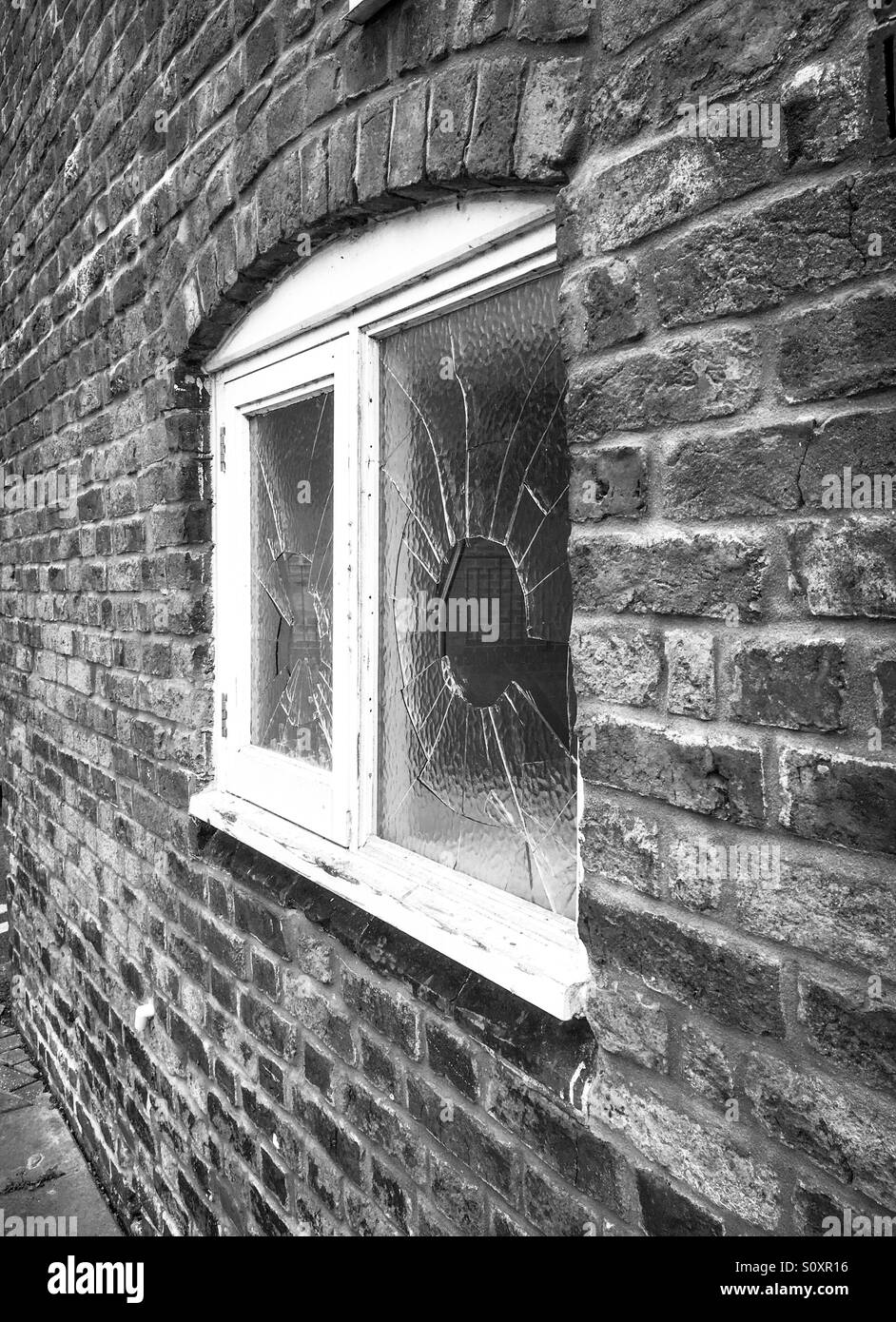 A broken window in a brick wall, in black and white Stock Photo - Alamy