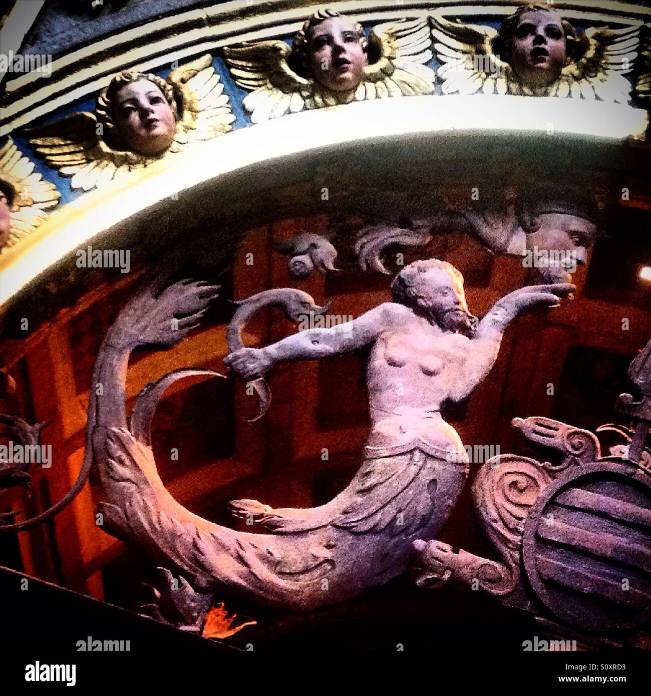 An sculpture of a triton, the male of the mermaid, holdins a snake is ...