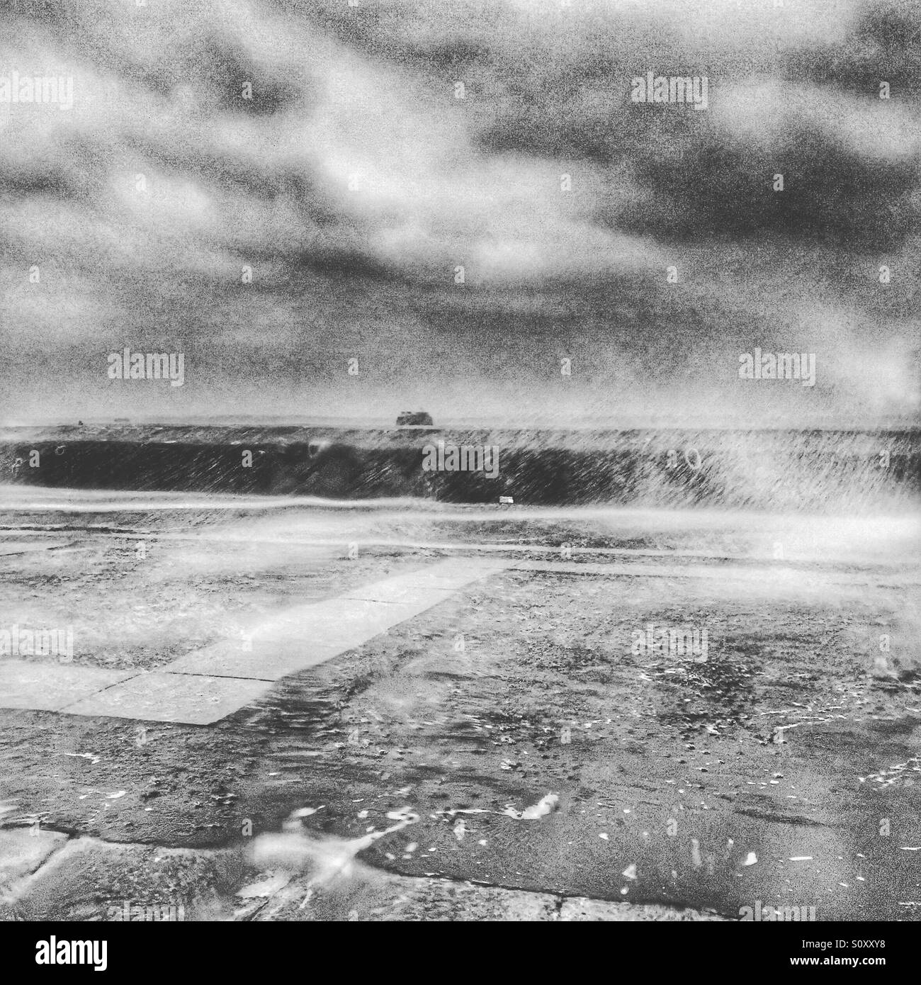 Waves crash over a sea-wall during stormy weather Stock Photo - Alamy