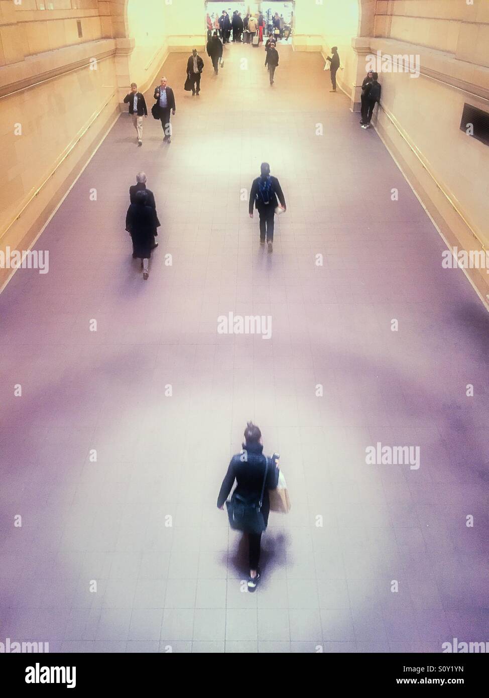 A lone woman traveler is highlighted walking up a ramp, Grand Central ...