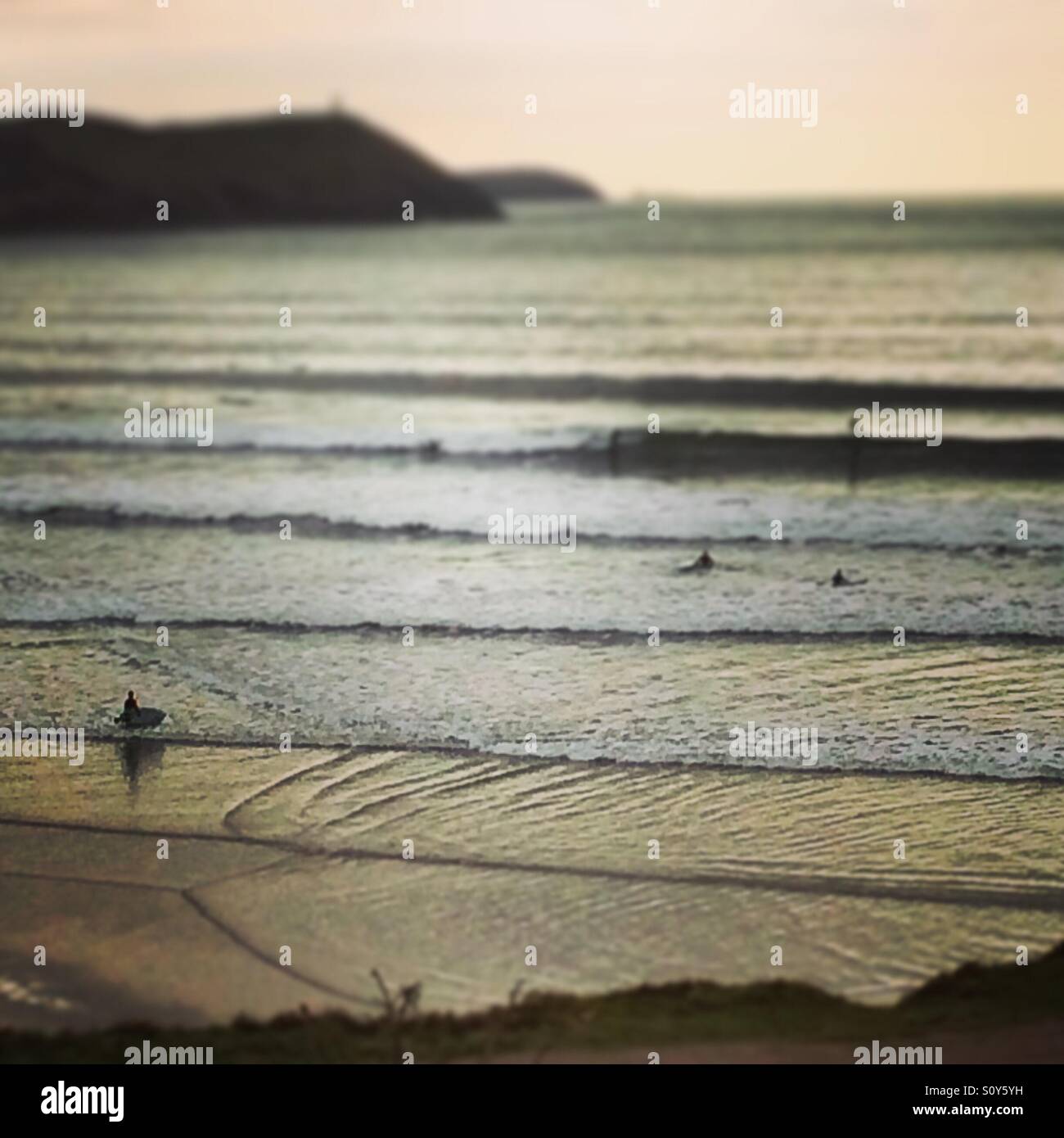 A surfer heads for the waves at Polzeath, North Cornwall Stock Photo ...