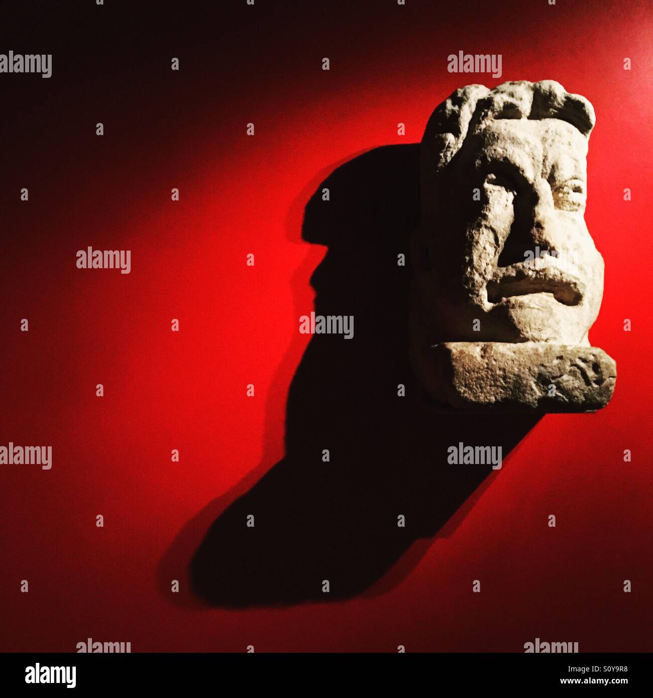 Head on a red wall, the Roman Baths Stock Photo - Alamy