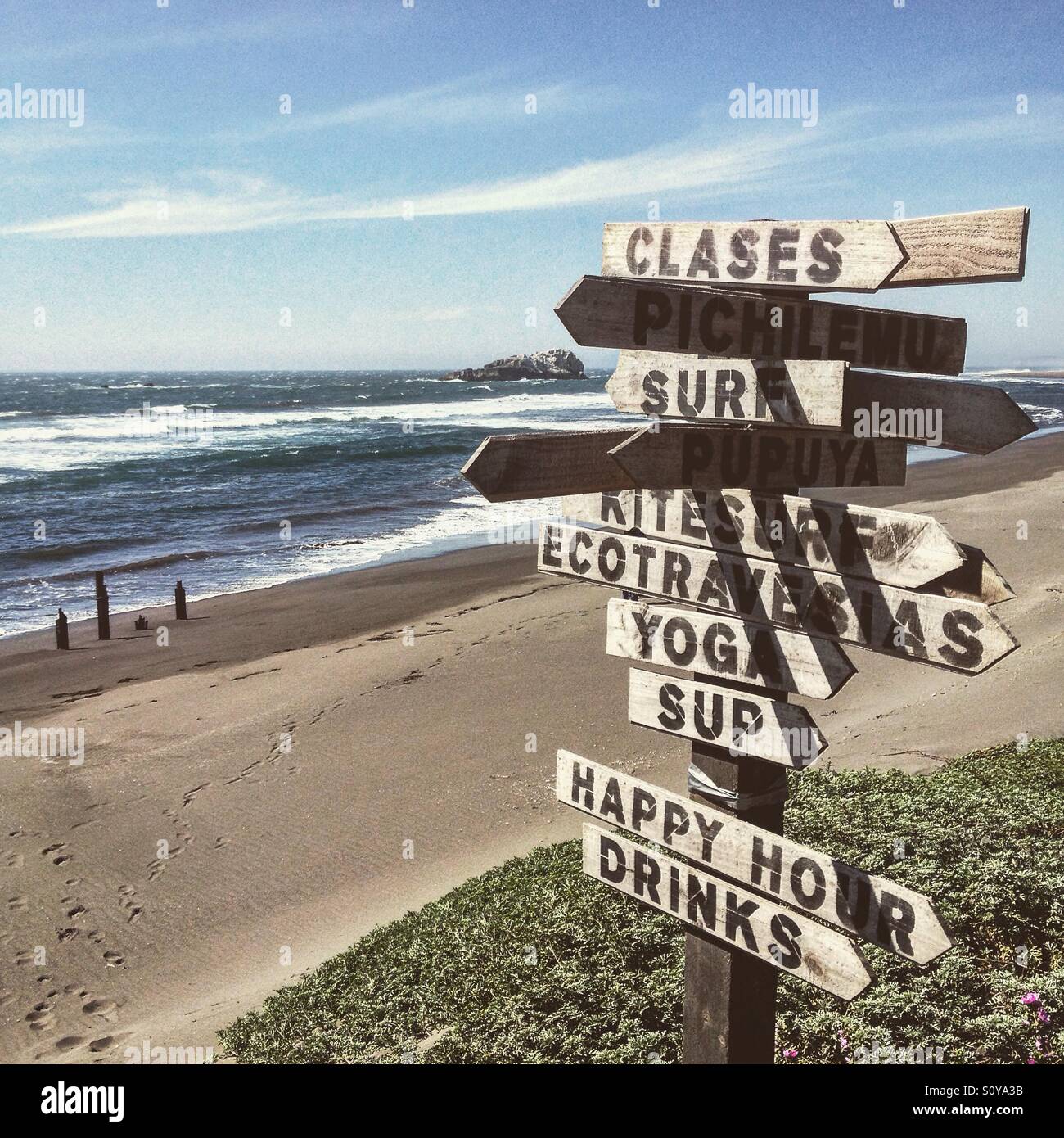 Wood post with multiple signs on a beach in Chile Stock Photo - Alamy