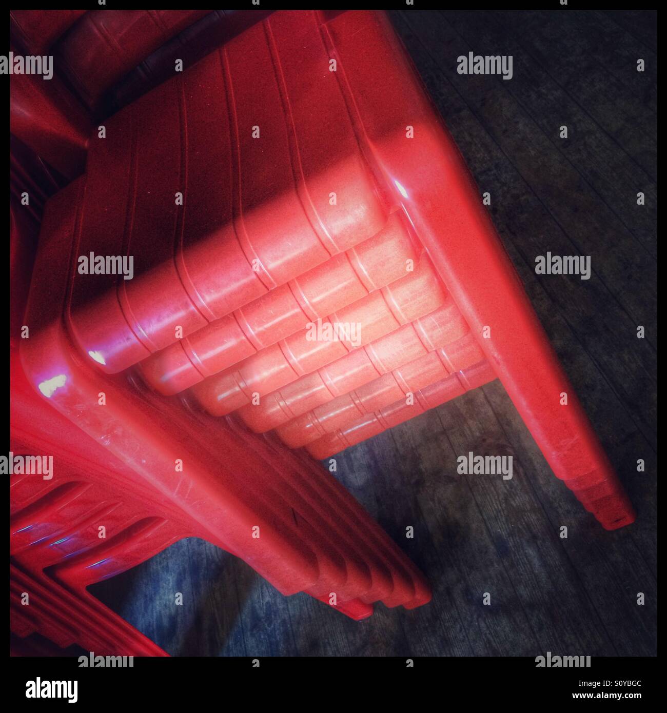 Stacked red plastic chairs Stock Photo - Alamy