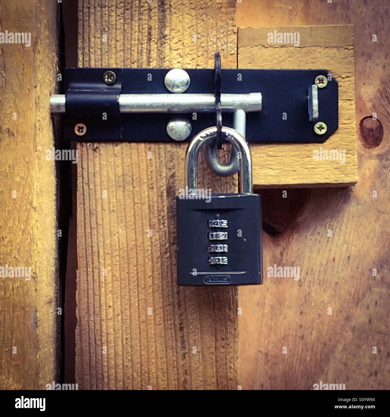 Padlock with combination lock on a wooden door Stock Photo - Alamy