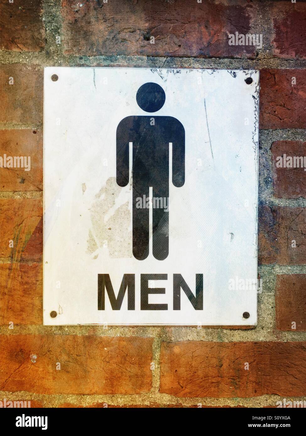 Men sign on red brick wall Stock Photo - Alamy