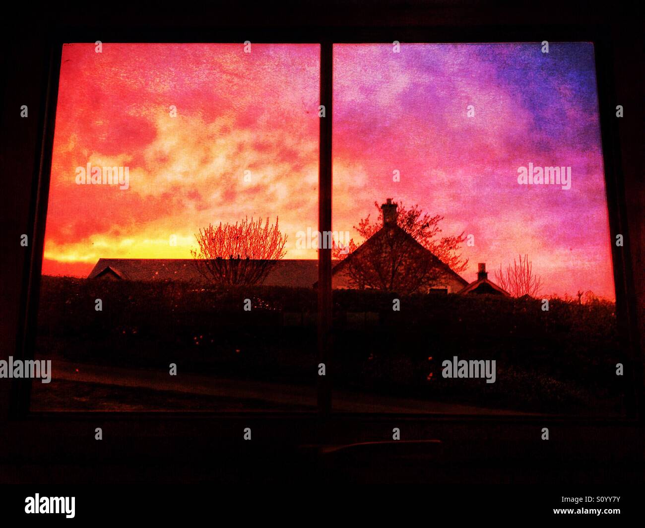 Sunset behind a silhouetted bungalow viewed through a window Stock ...