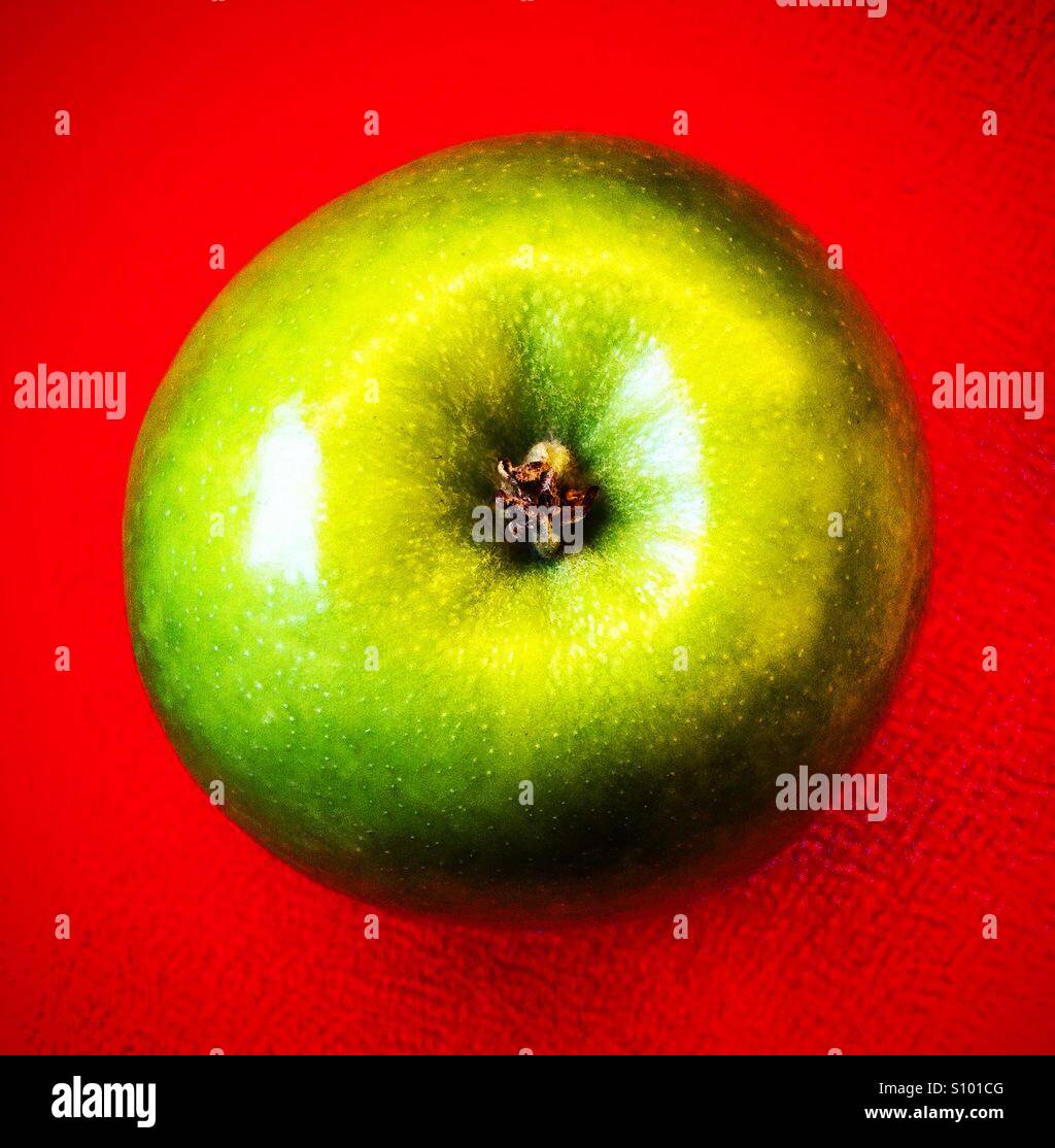 Green apple top view on red background Stock Photo - Alamy
