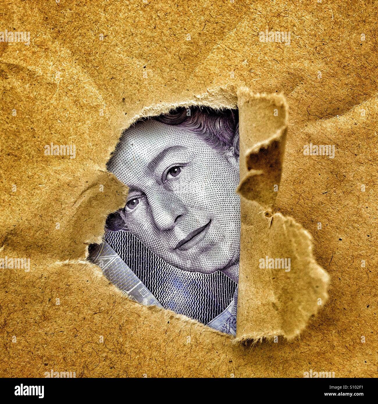 Queens head on twenty pound note through hole in brown envelope Stock ...