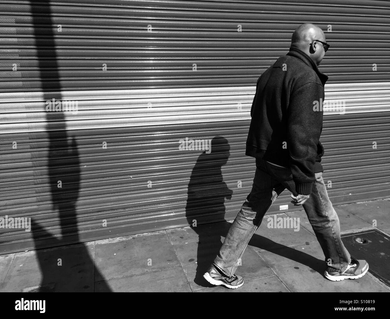 Man in shadows walking hi-res stock photography and images - Alamy