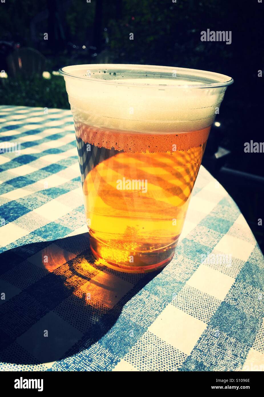 Draft beer on outside picnic table in plastic cup Stock Photo - Alamy