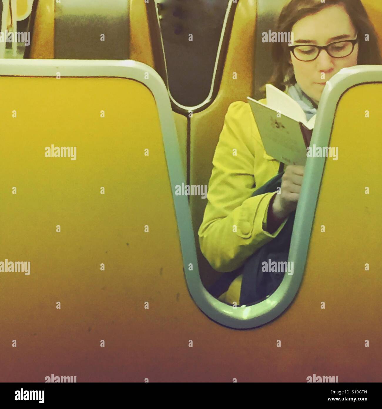 Woman reading on the subway Stock Photo - Alamy