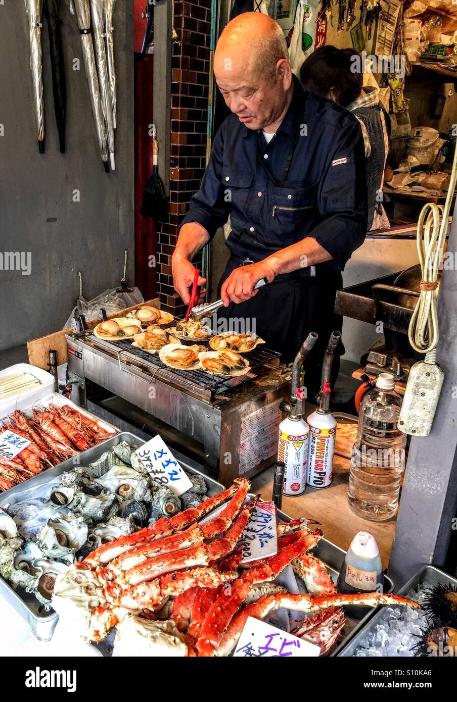 Vendor preparing seafood at market in Tokyo Japan Stock Photo - Alamy