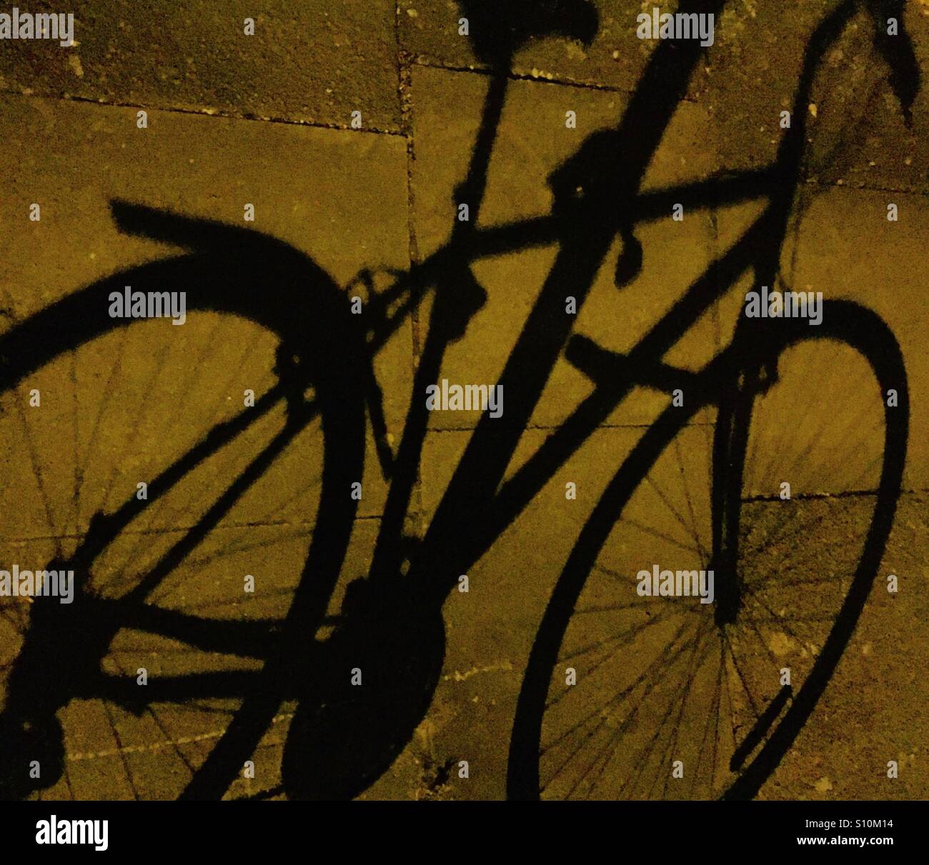Shadow of a locked bike at night Stock Photo - Alamy