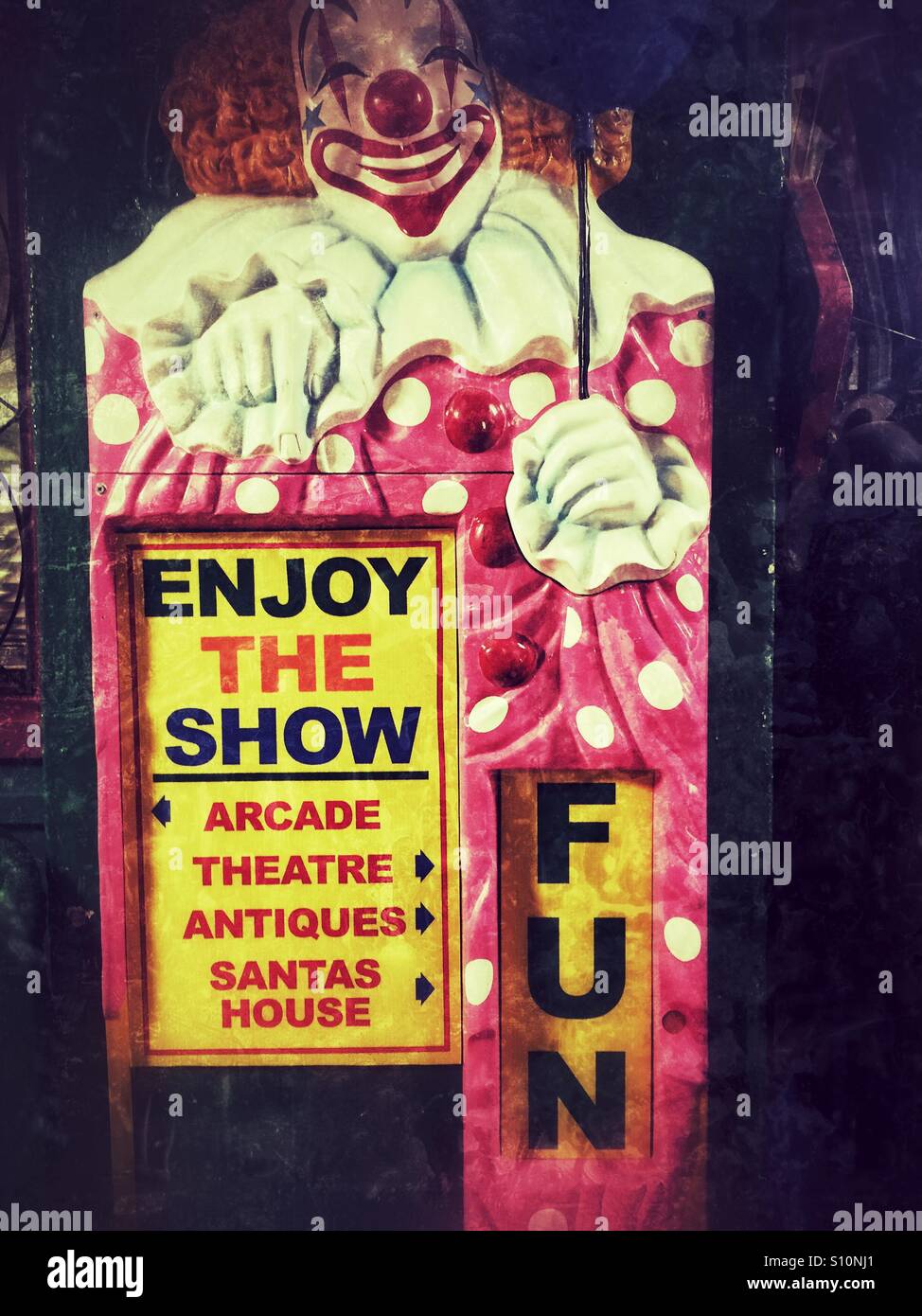 Grunge fun house image of clown holding an "enjoy the show" sign ...