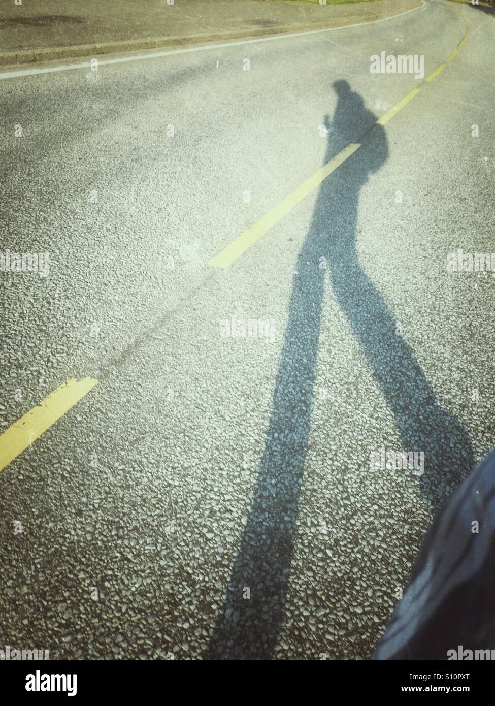 Shadow of a man croasing a road Stock Photo - Alamy