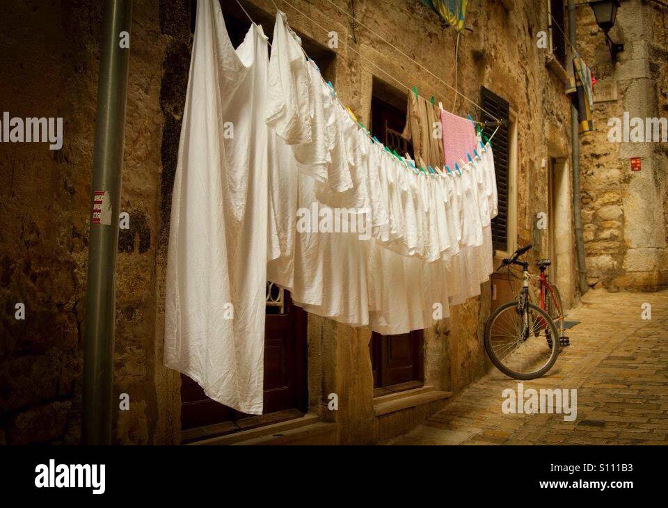 White sheets drying on the rope on the street Stock Photo - Alamy