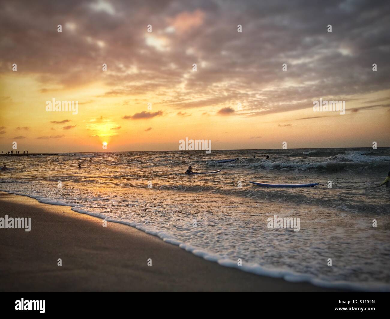 Surfers at sunset in La Union, Philippines Stock Photo - Alamy