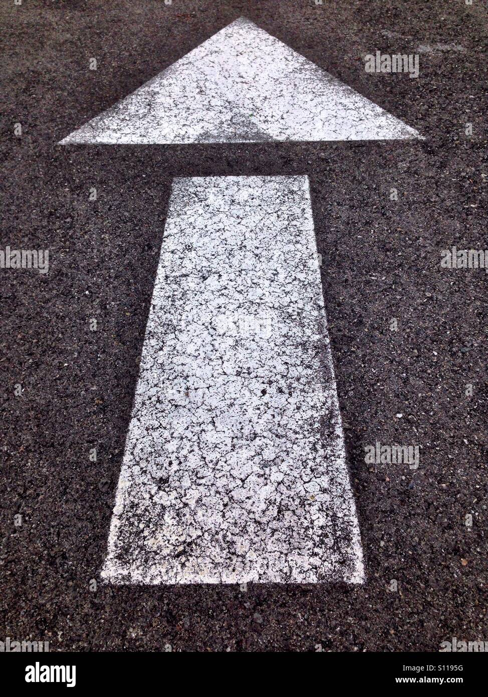 White arrow on black pavement Stock Photo - Alamy