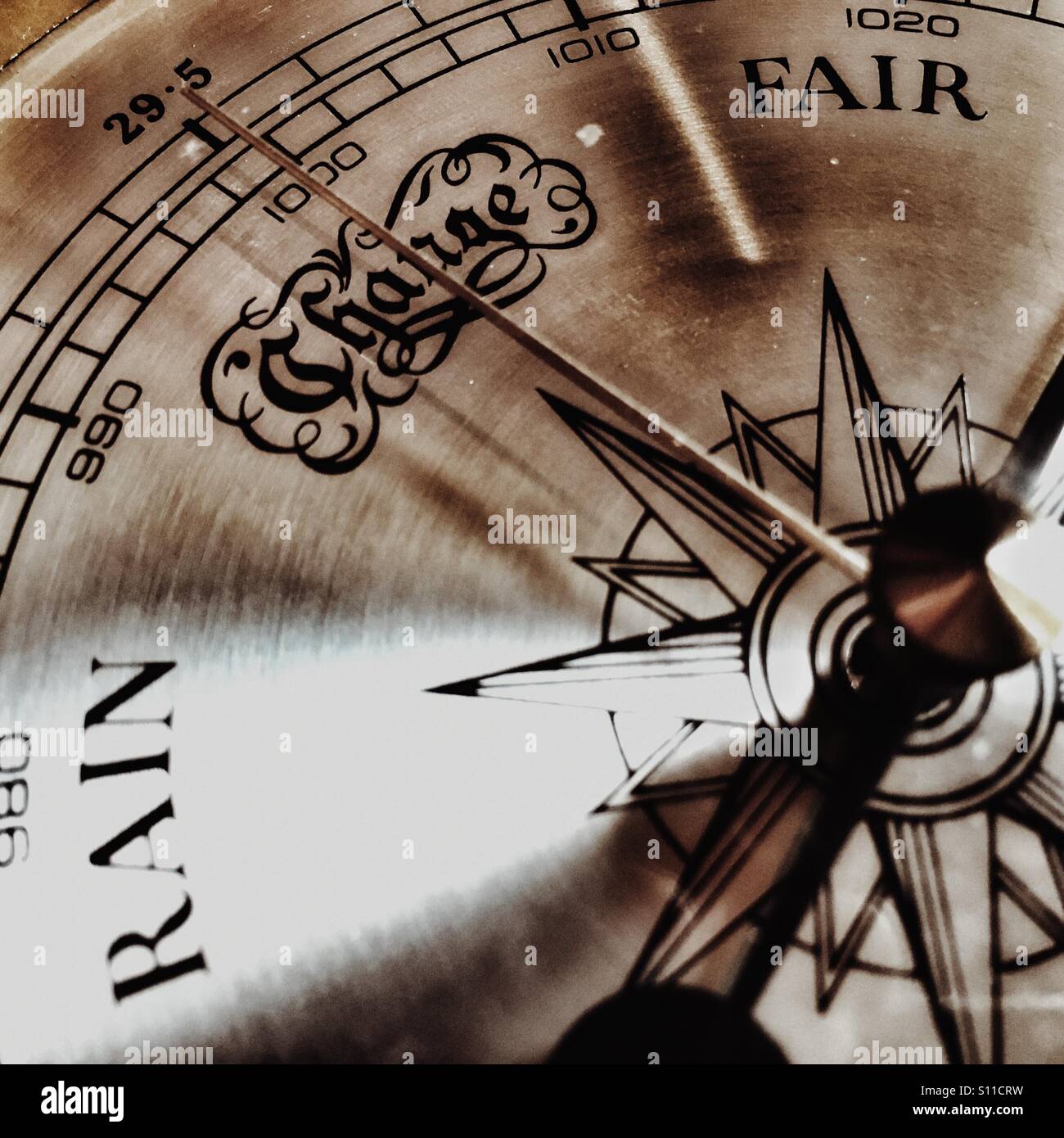 Barometer, showing the words rain, change and fair. The needle points ...