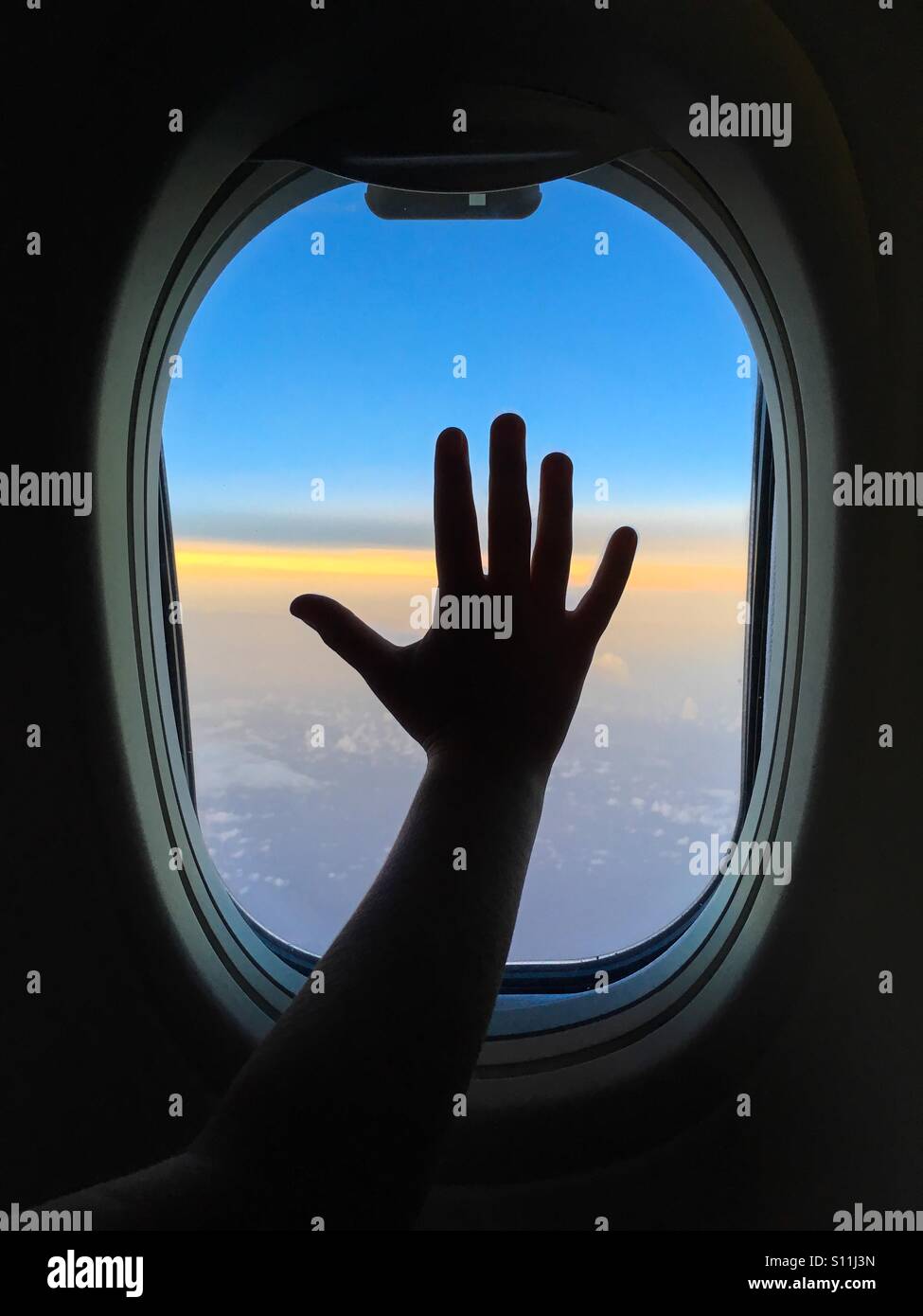 Hand of a child on an airplane window Stock Photo - Alamy