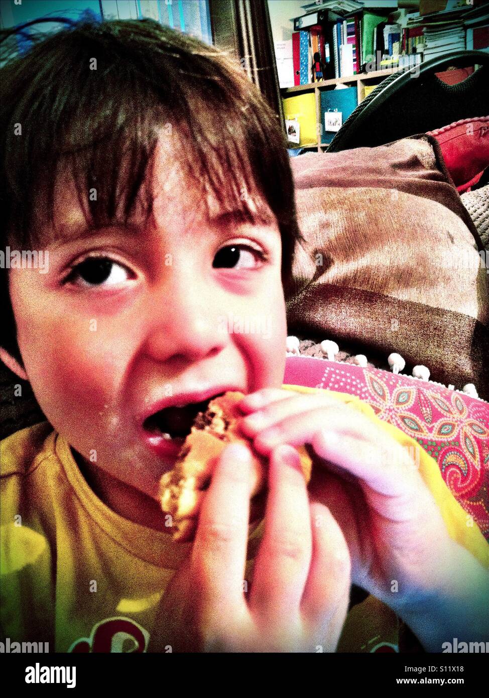 A young boy eating a cookie Stock Photo - Alamy
