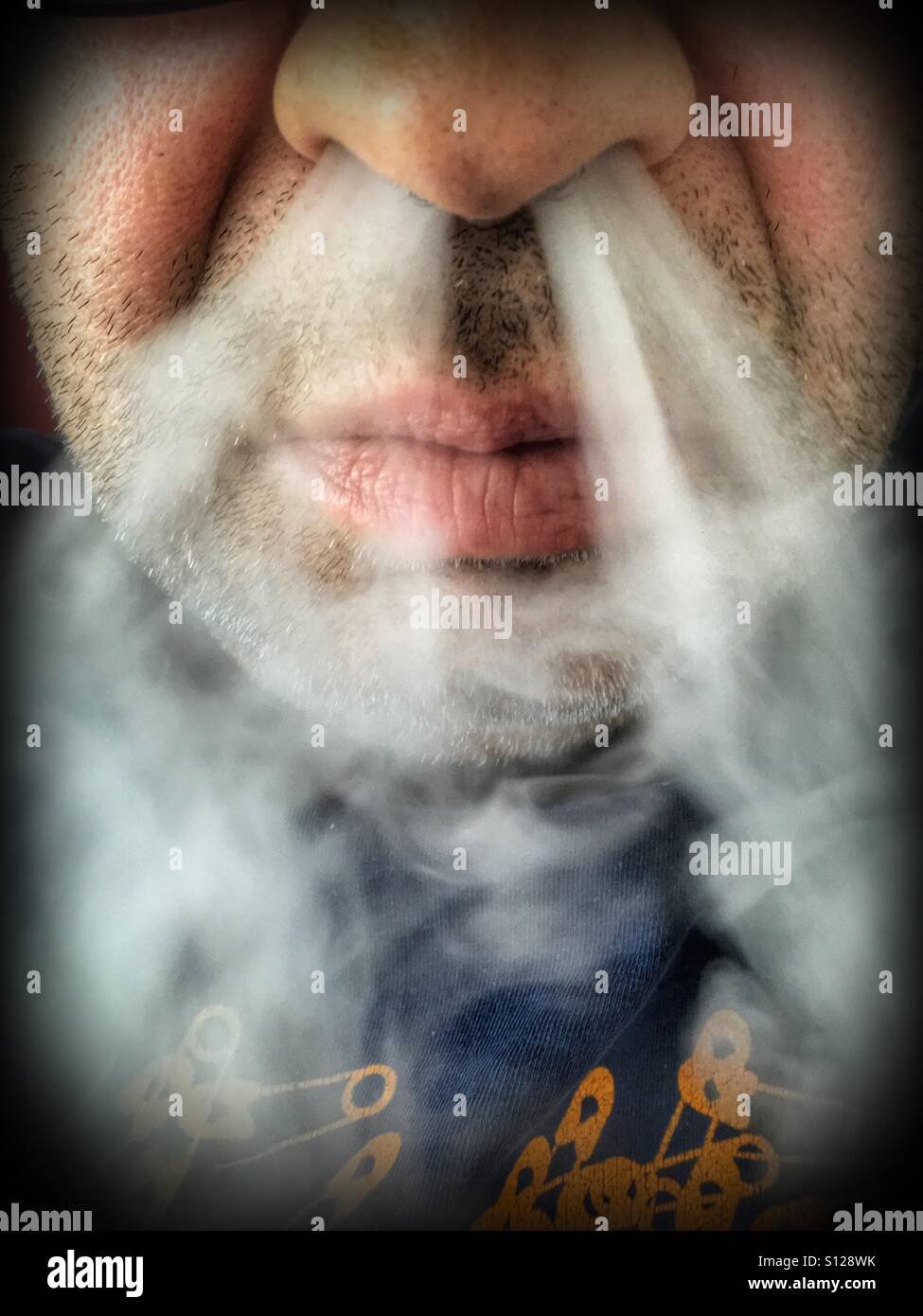 Man vaping and blowing vaping smoke through his nostrils Stock Photo ...