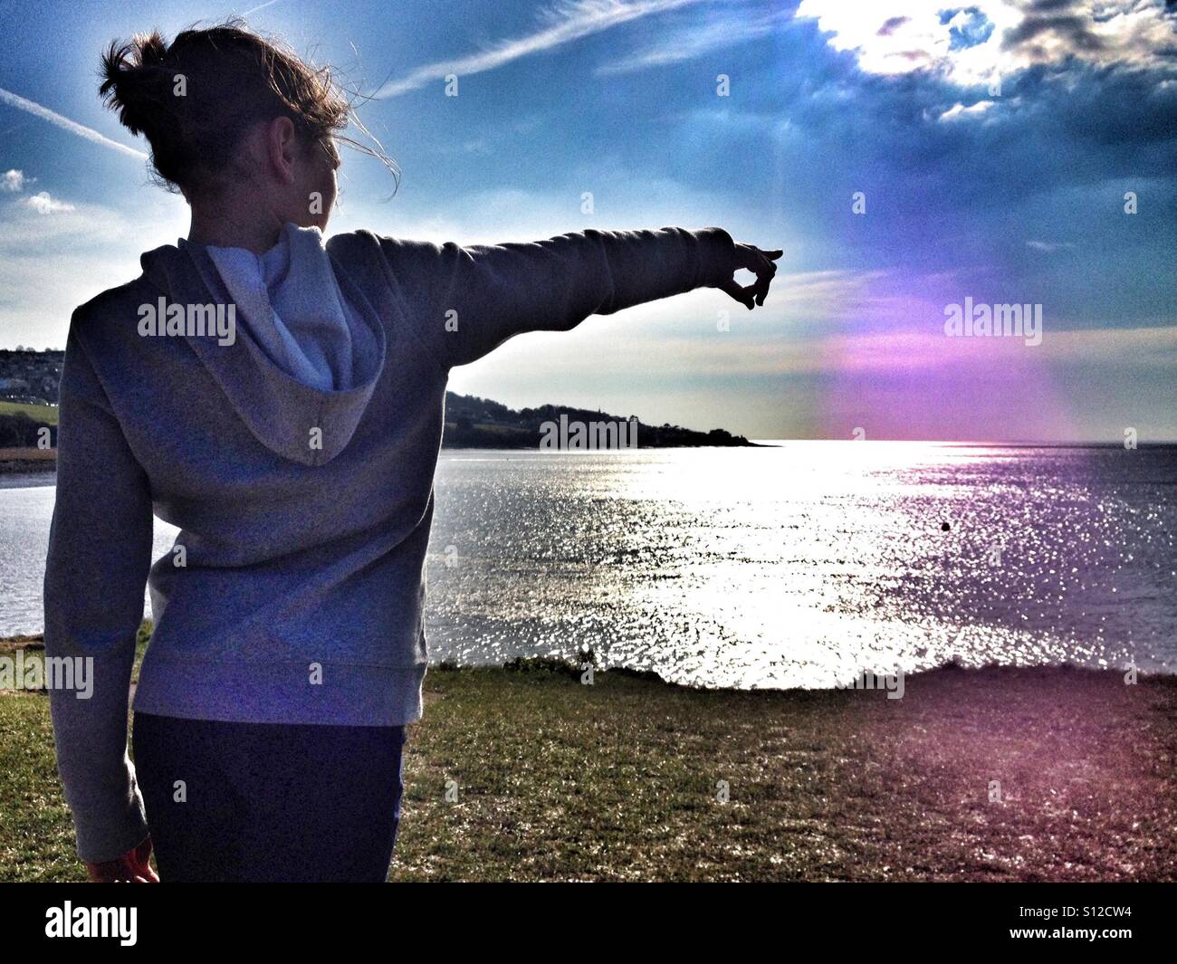 Young girl pointing out to sea Stock Photo - Alamy