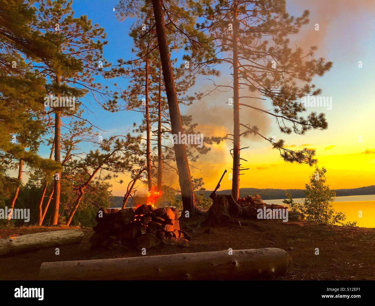 Log Benches At Campfire With Golden Sunlight At Lake Stock Photo - Alamy